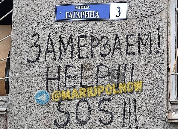 "We are freezing. Help. Sos" signs with pleas for help appear in Mariupol